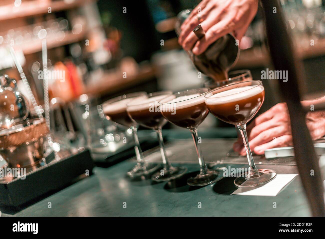 The bartender making an alcoholic cocktail, a summer cocktail in the ...
