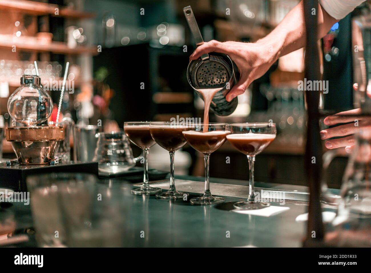 The bartender making an alcoholic cocktail, a summer cocktail in the ...