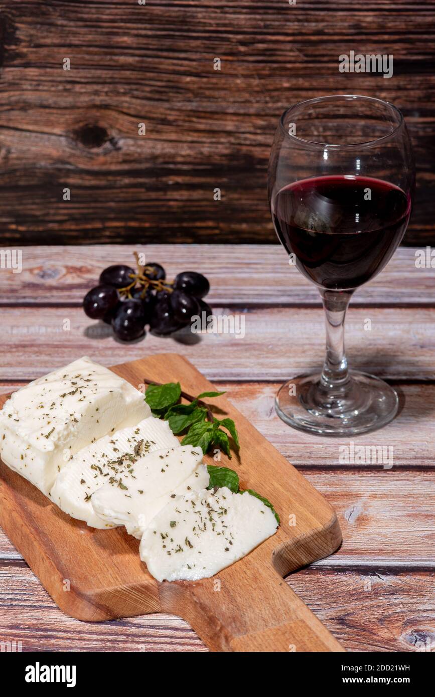 Traditional cyprus halloumi cheese, red wine and grapes on a table ...