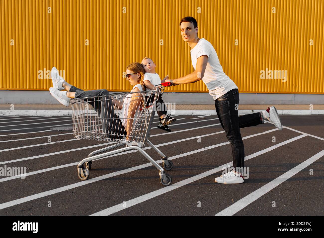 Excited happy family having fun ride on shopping cart outdoors, family ...
