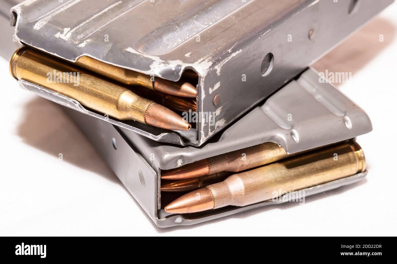 Two loaded rifle magazines with 223 caliber bullets on a white ...