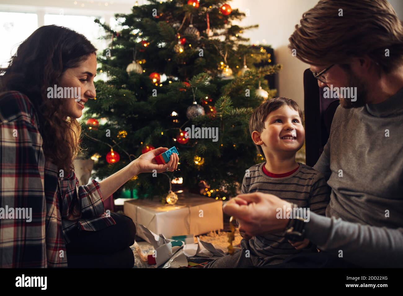 Happy small family celebrating Christmas together. Father, mother and ...