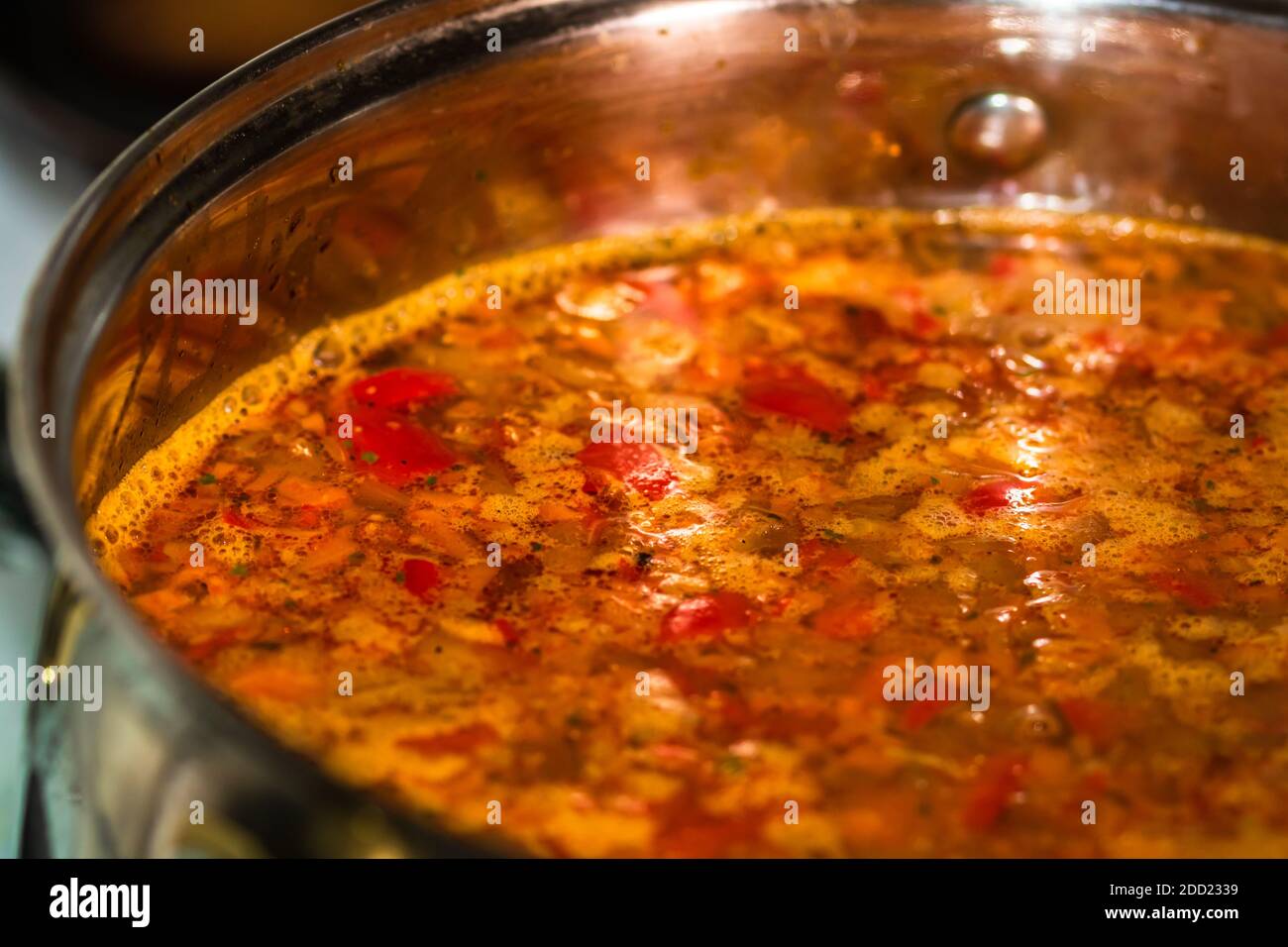 Preparation of soup with chicken and vegetables. Close up of boiling ...