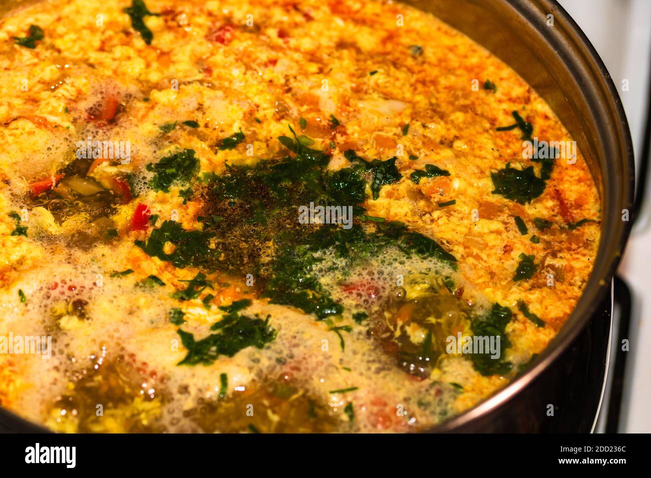 Preparation of soup with chicken and vegetables. Close up of boiling ...