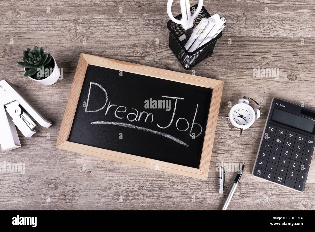 A top view of an office desk with a black chalkboard with text "Dream ...
