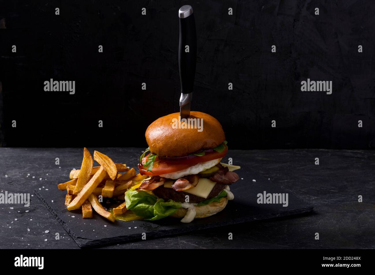 Homemade loaded burger of lettuce, mayo, meat, cheese, bacon, egg ...