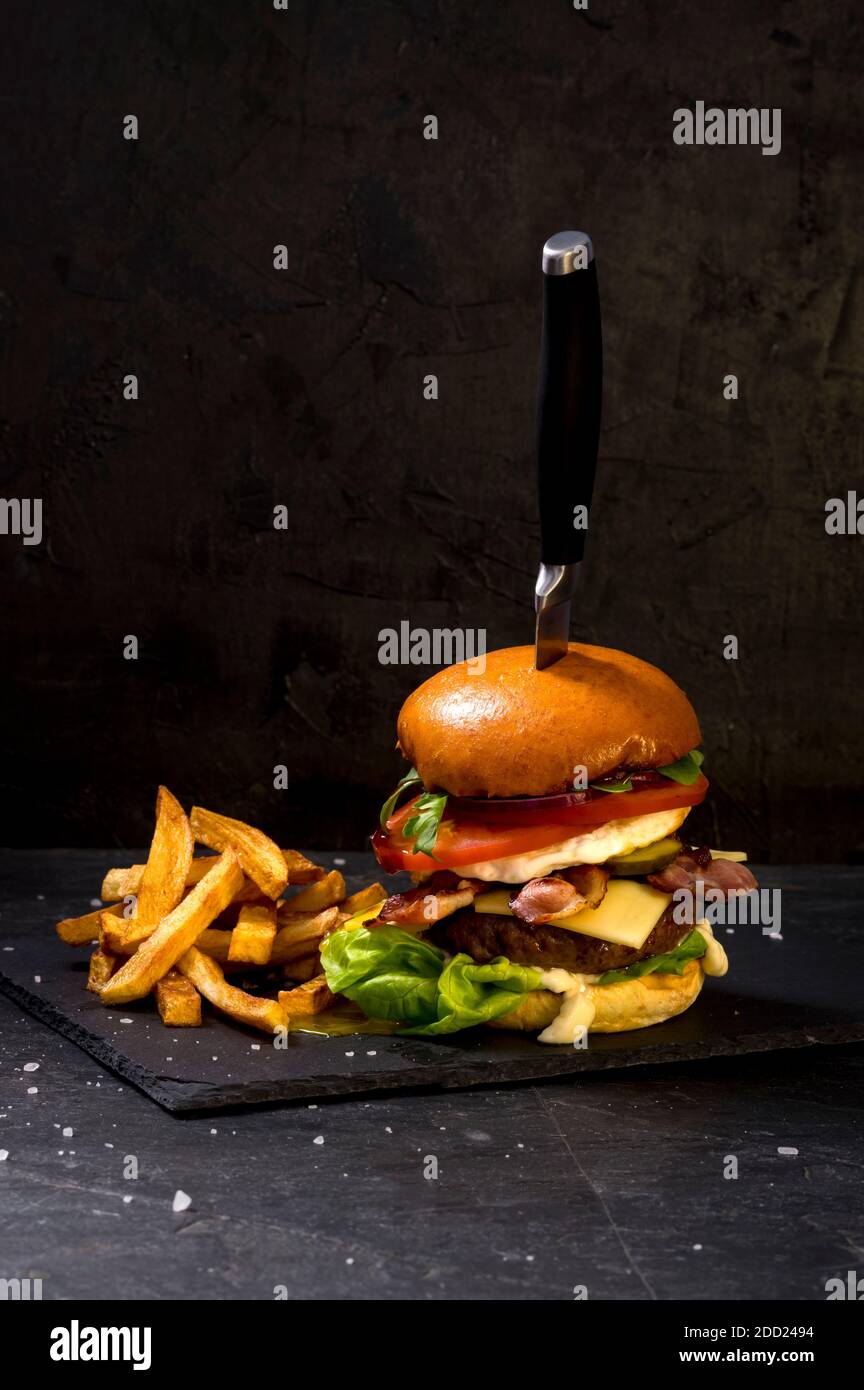 Homemade loaded burger of lettuce, mayo, meat, cheese, bacon, egg ...