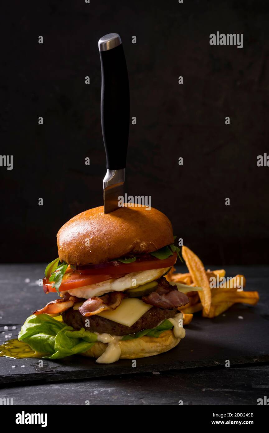 Homemade loaded burger of lettuce, mayo, meat, cheese, bacon, egg ...