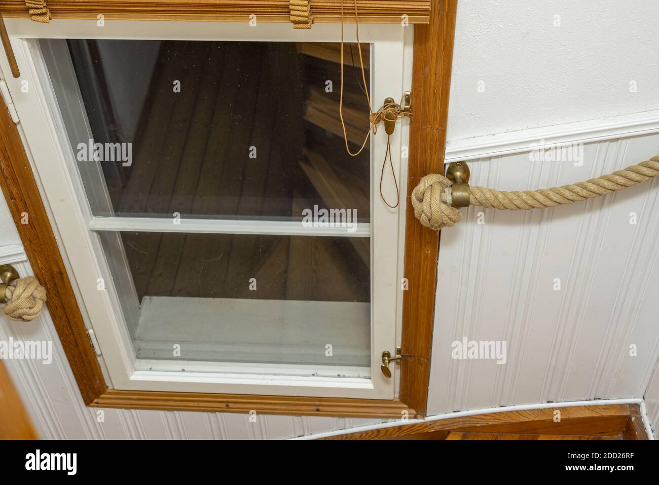 Close up view of stair window with brown frame and nautical rope ...
