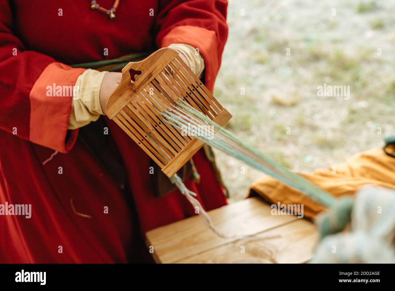Weaving craft. Woman in traditional dress works with hands Stock Photo ...