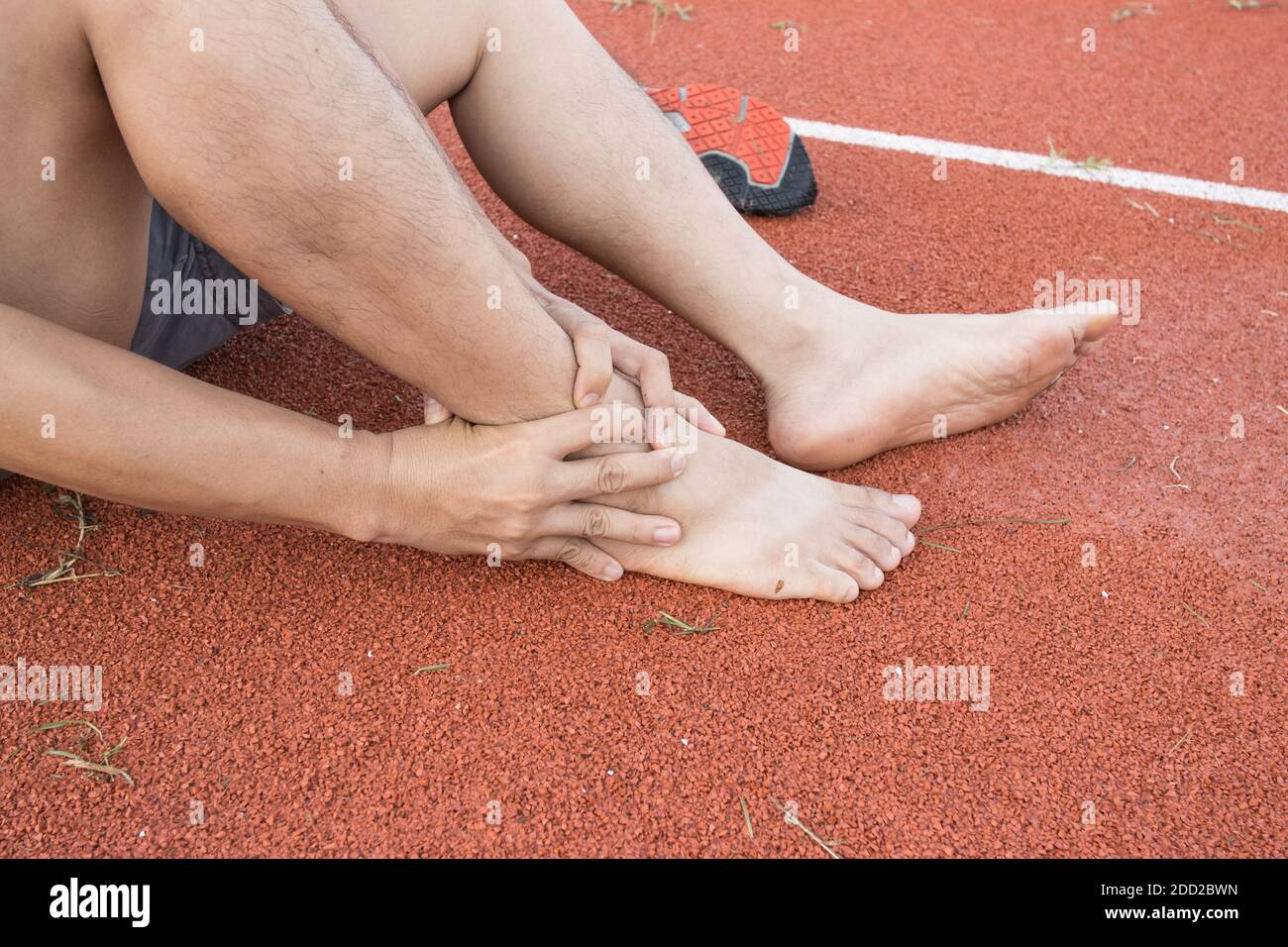 man ankle injury after running at Running field Stock Photo - Alamy
