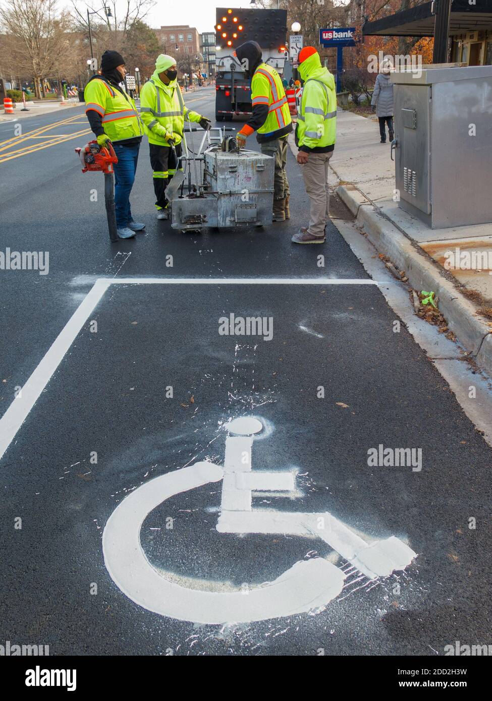 Pavement painting crew and completed wheelchair icon in handicapped ...