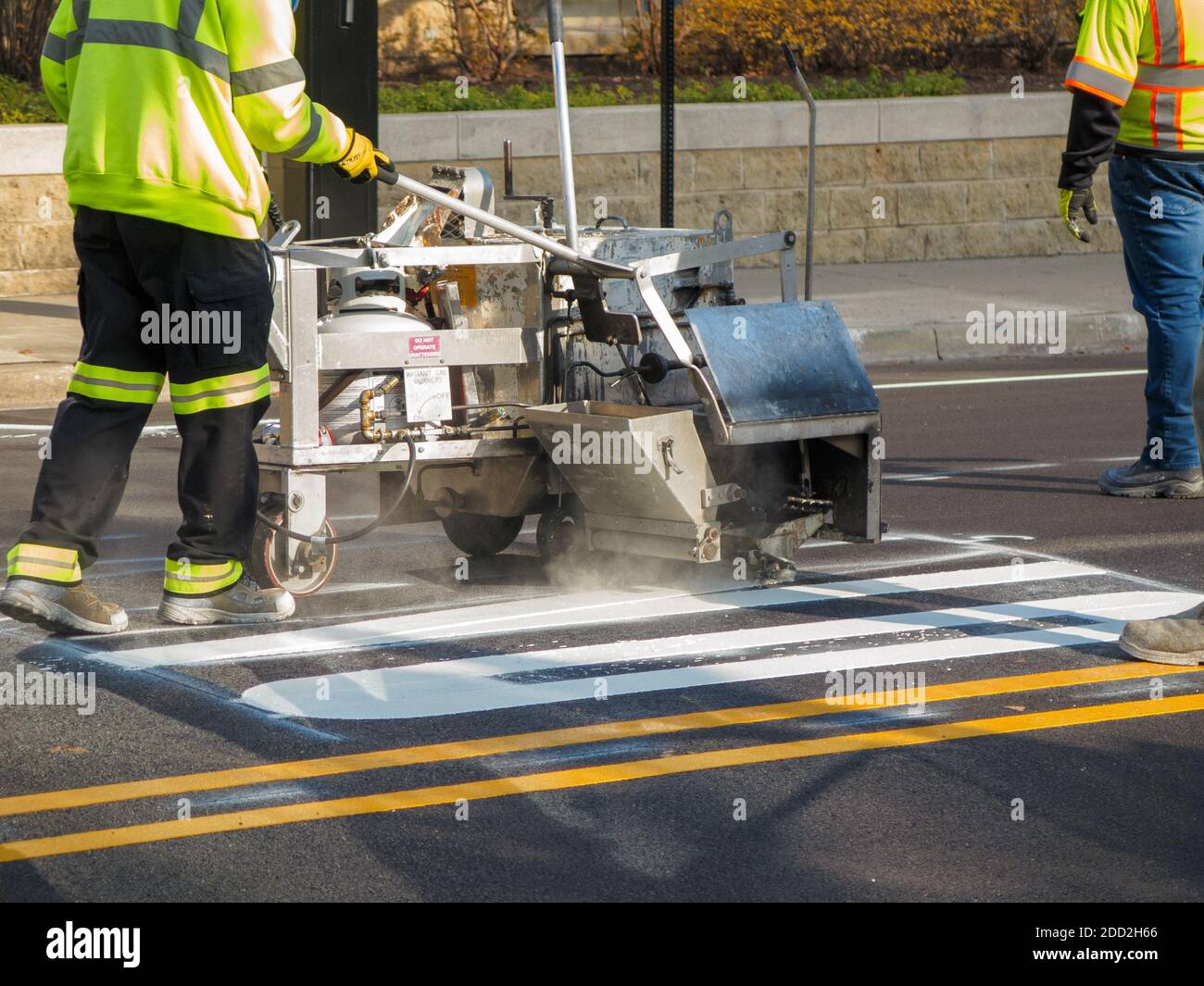 Pavement painting crew using painting machine laying down traffic ...