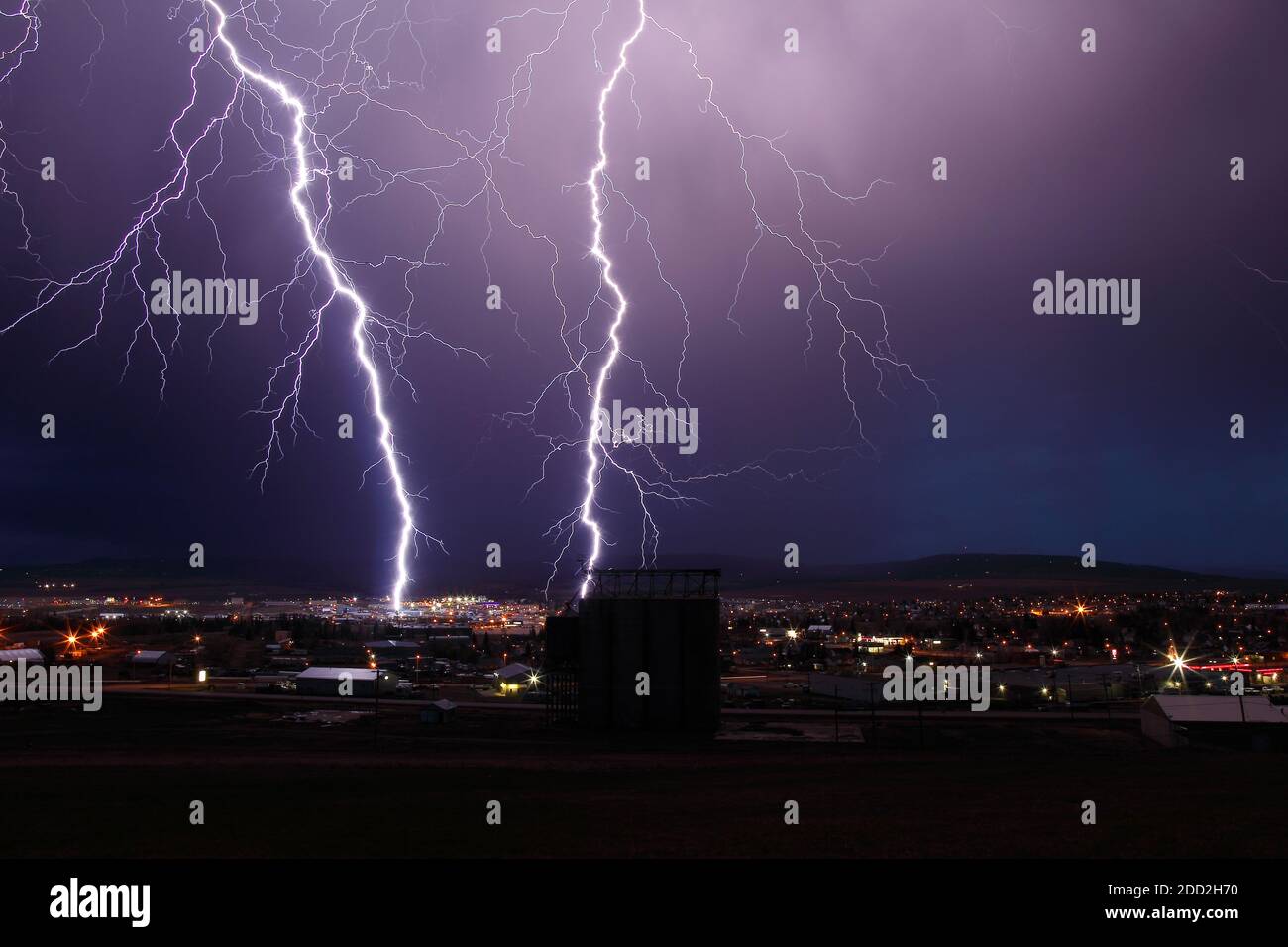 Direct lightning strikes from stormy skies over cityscape Stock Photo ...