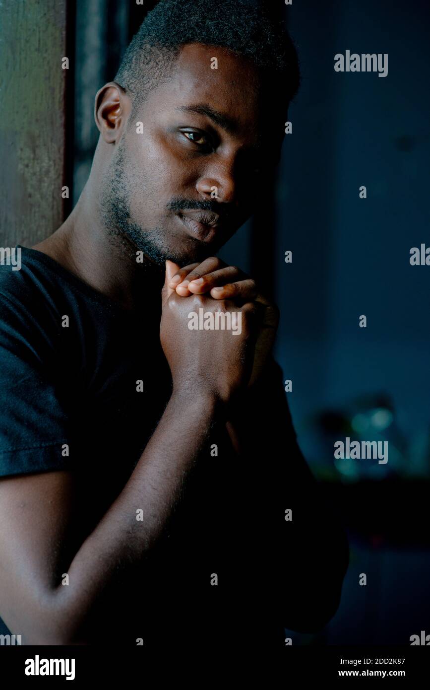 Sad african man standing in dark room. Depression and anxiety disorder ...