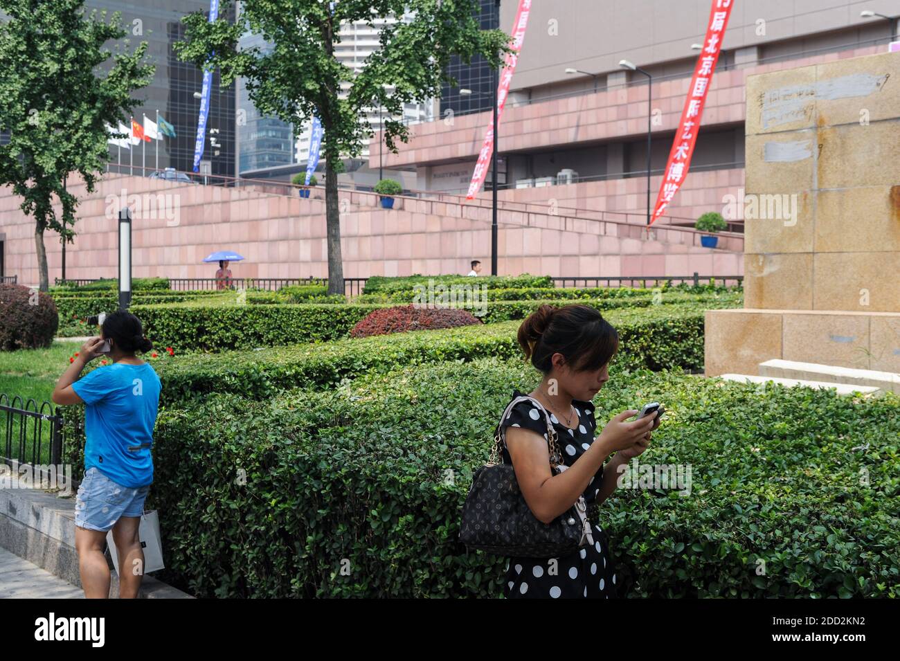 16.08.2012, Beijing, China, Asia - Two women use their mobile phones in ...