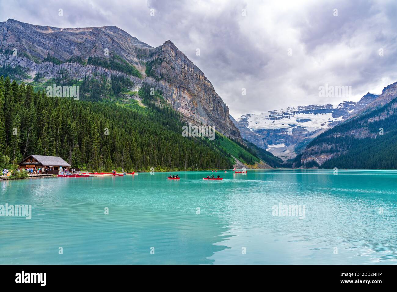 Canoeing on Lake Louise in summer day. Tourists enjoy leisure water ...