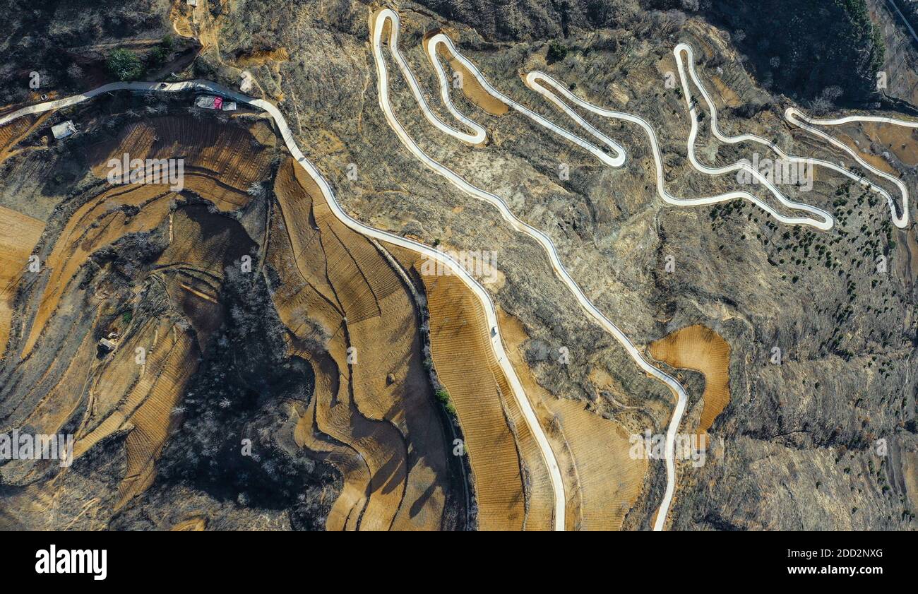 The western mountains of narrow road and crescent field Stock Photo - Alamy