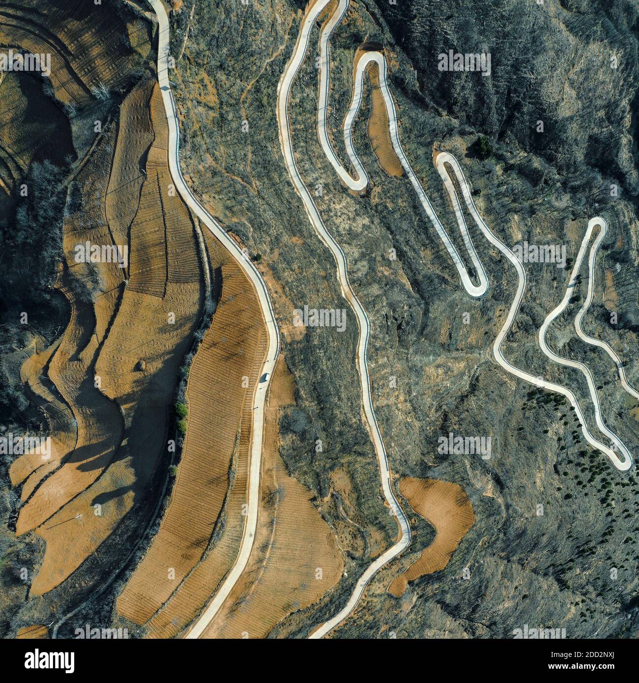 The western mountains of narrow road and crescent field Stock Photo - Alamy