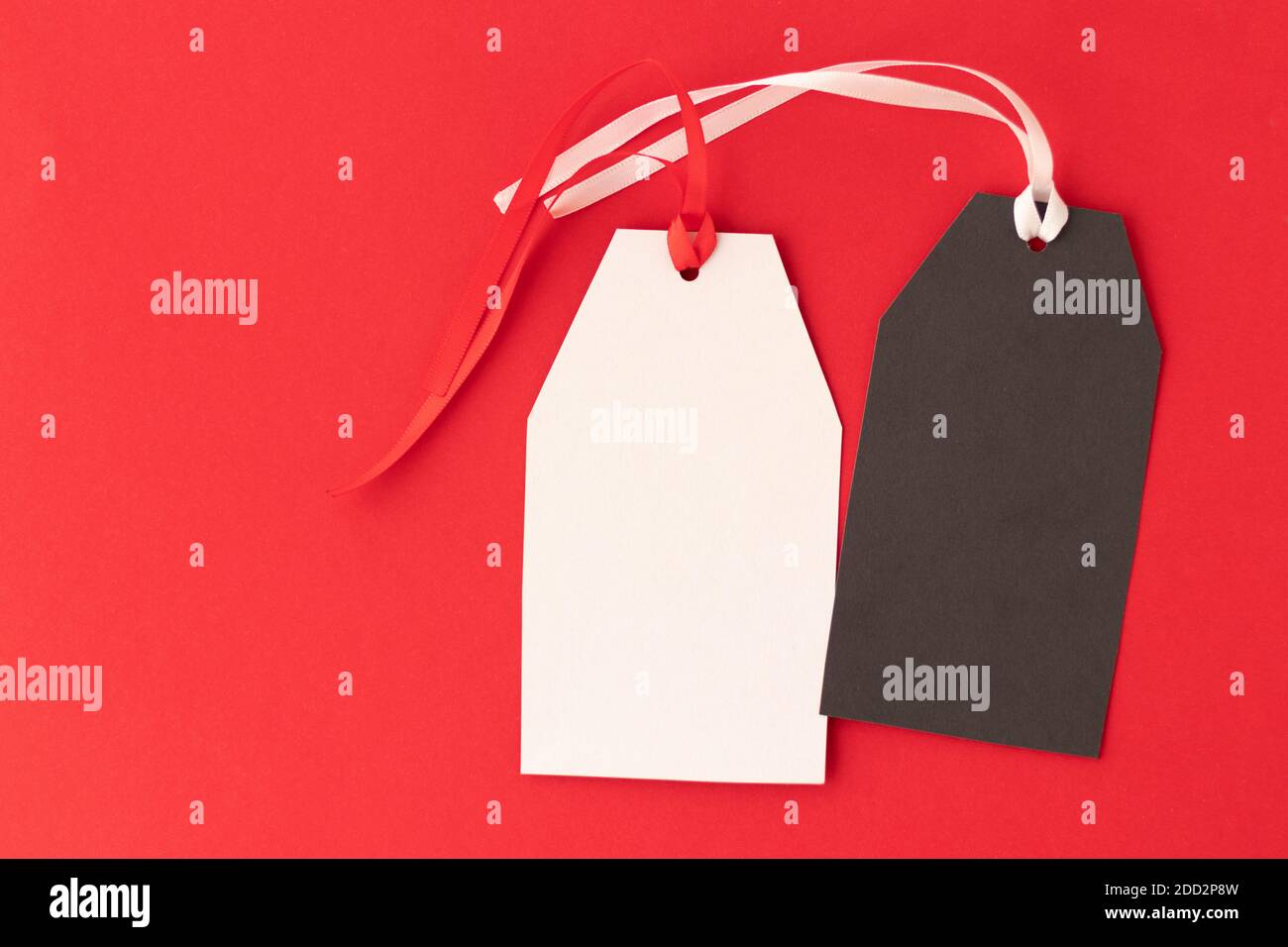 Two empty tags on a red background. Copy space for your text. Black ...