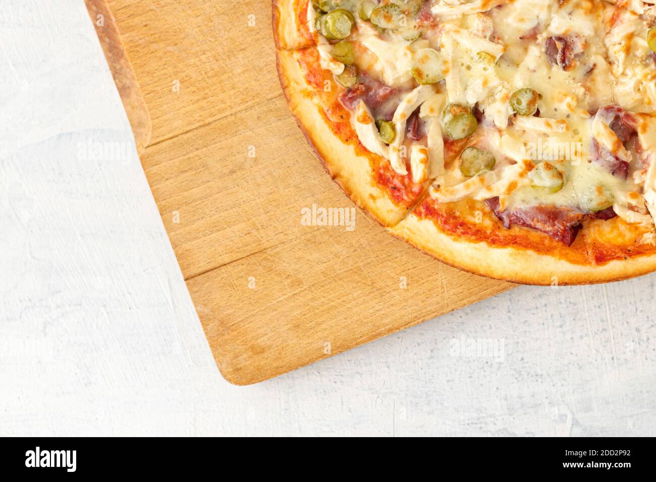 Rustic pizza with salami, mozzarella, cucumbers and chiken top view ...