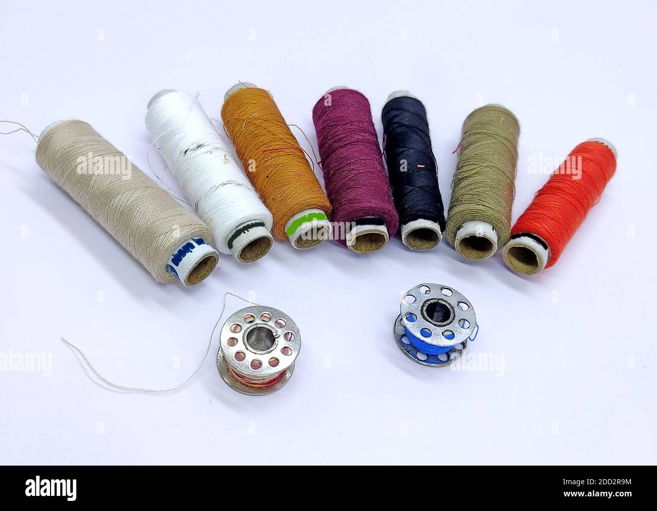 Old vintage hand sewing machine Colored thread coils or bobbin on white ...