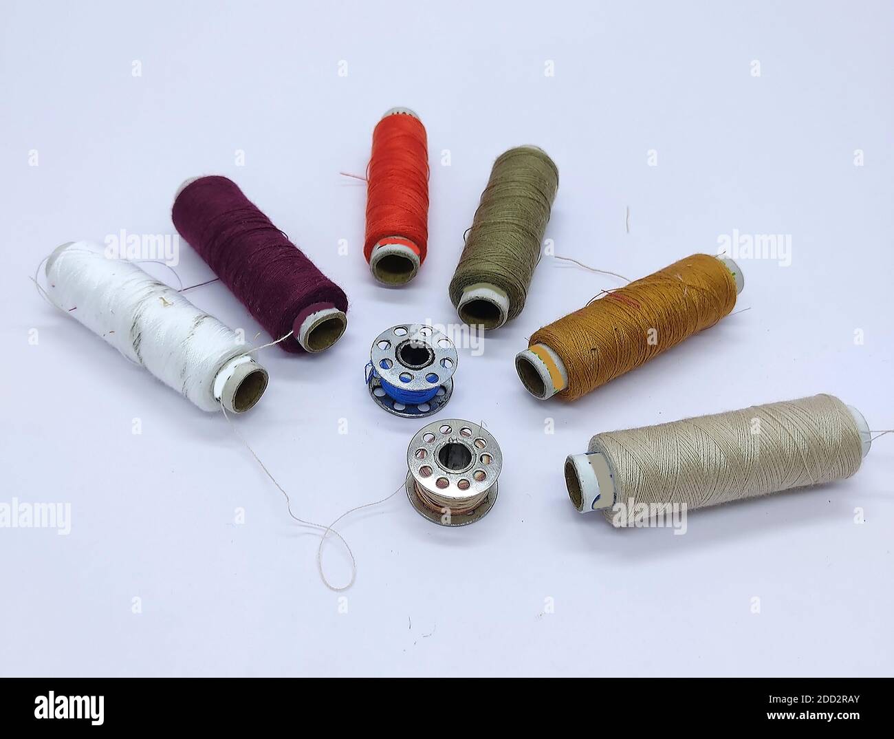 Old vintage hand sewing machine Colored thread coils or bobbin on white ...