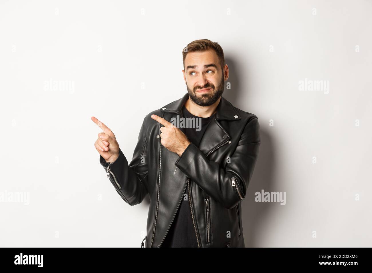 Skeptical and doubtful guy in black leather jacket, shrugging while ...