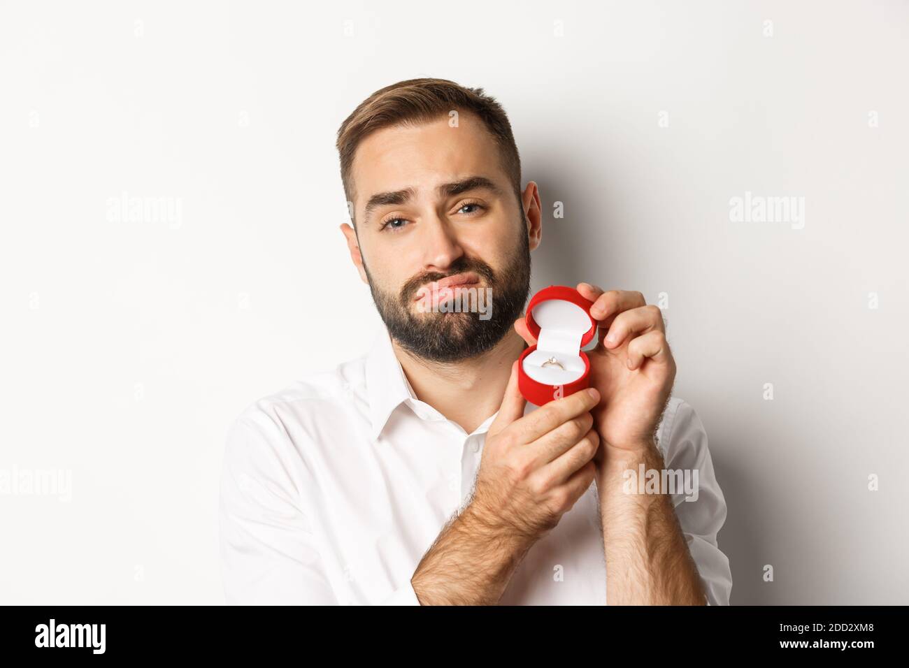 Close-up of hopeful man begging to marry him, looking sad and showing ...