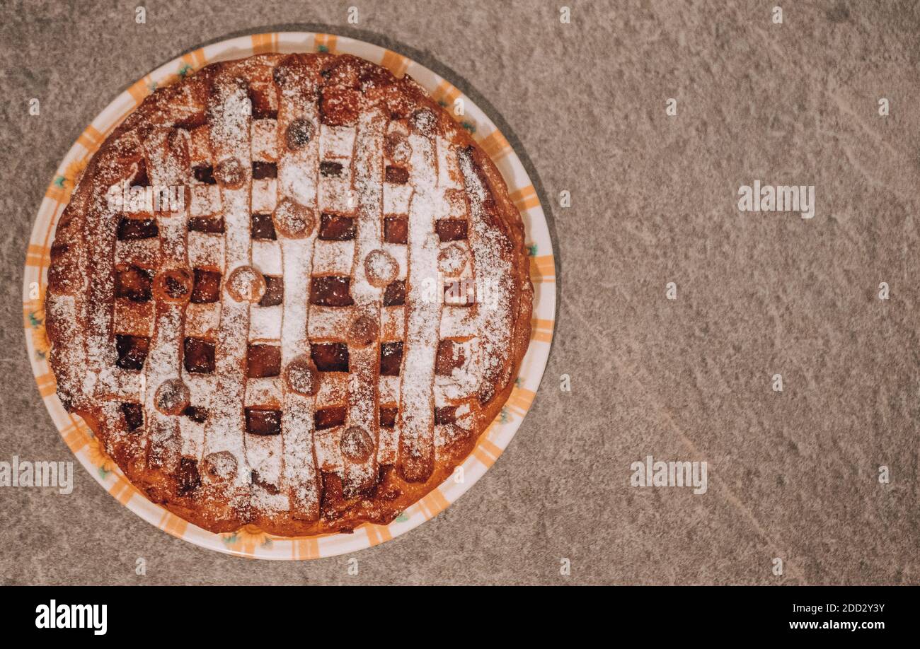 Apple pie with raisins and cinnamon on vintage concrete background ...