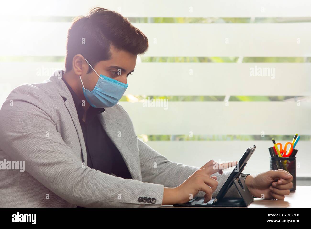 A YOUNG PROFESSIONAL WEARING MASK WORKING Stock Photo - Alamy