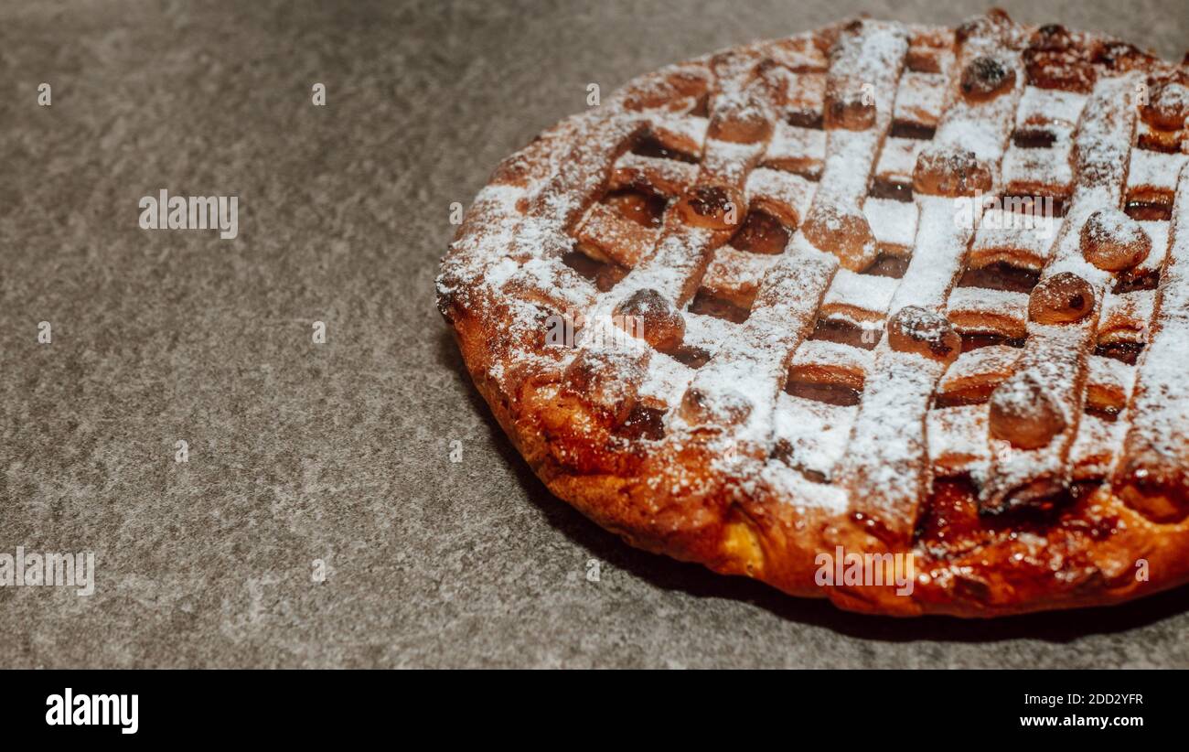 Apple pie with raisins and cinnamon on vintage concrete background ...