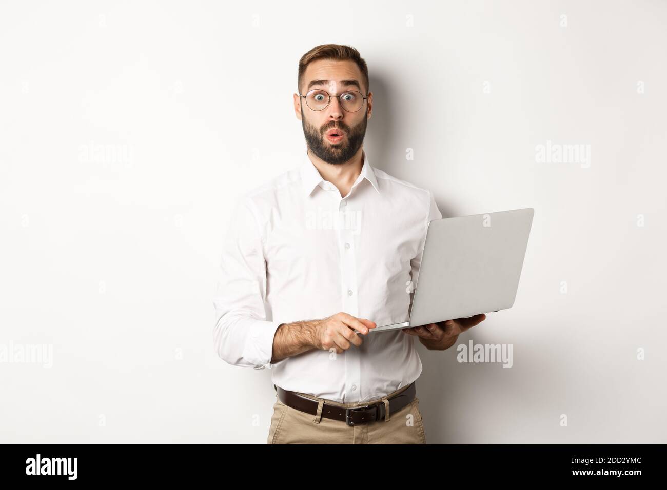 Business. Surprised business man holding laptop and looking interested ...