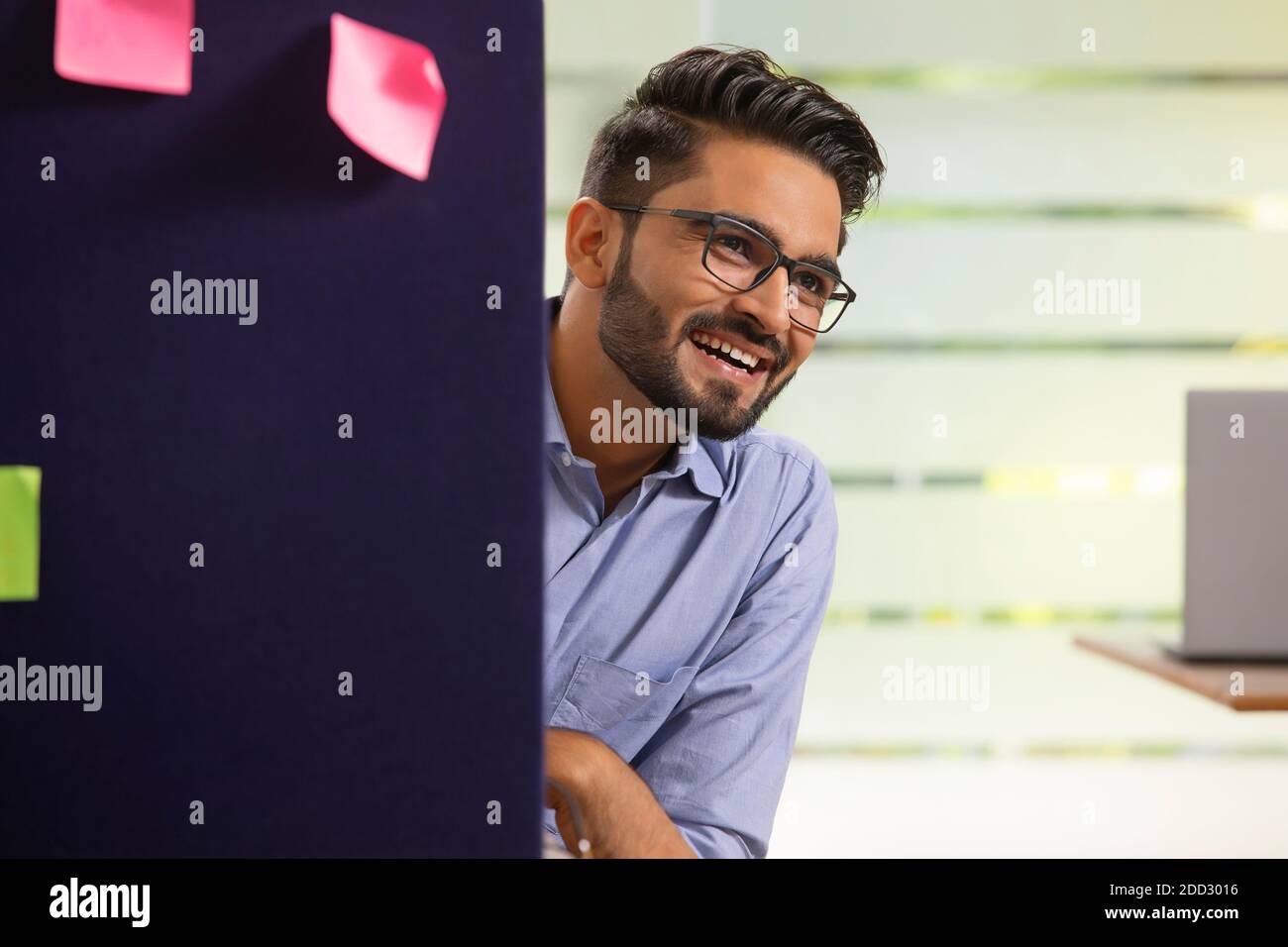 A YOUNG MAN SITTING AND HAPPILY TALKING TO COLLEAGUES Stock Photo - Alamy