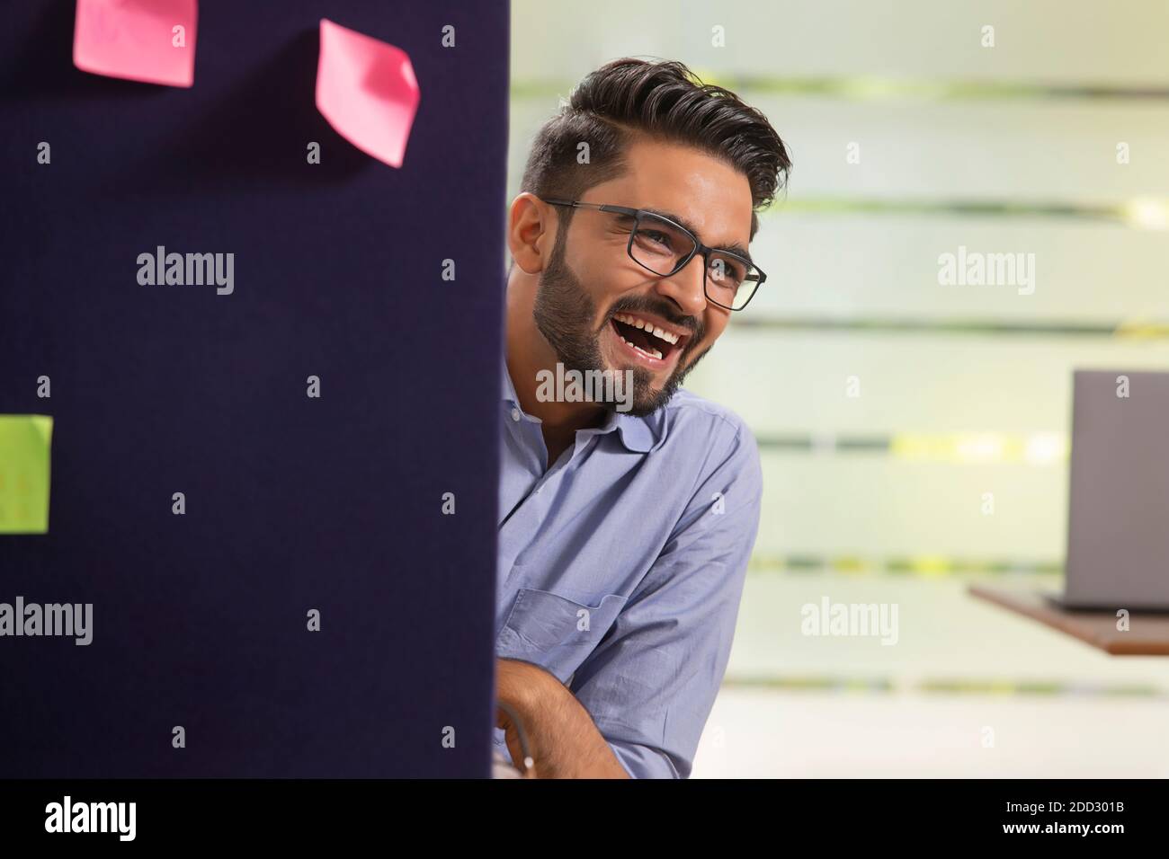 AN OFFICE EXECUTIVE LAUGHING AND TALKING TO COLLEAGUES WHILE SITTING IN ...