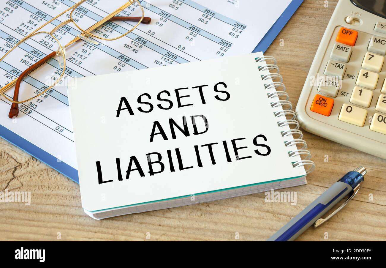 Asset and Liability is written on a notepad on an office desk with ...