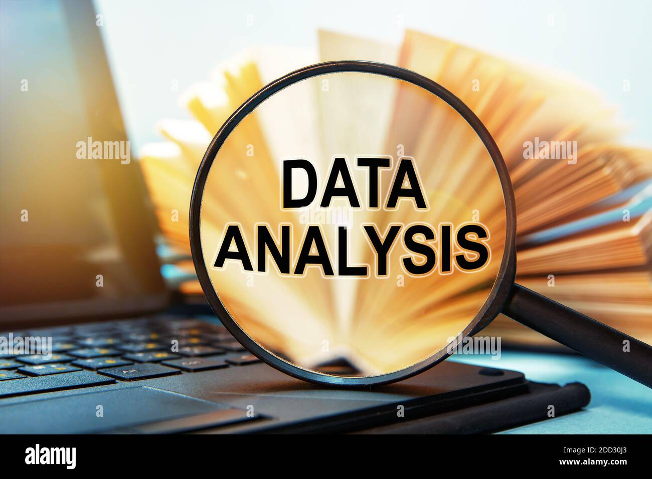 Laptop computer and book with a magnifying glass. Text DATA ANALYSIS on ...