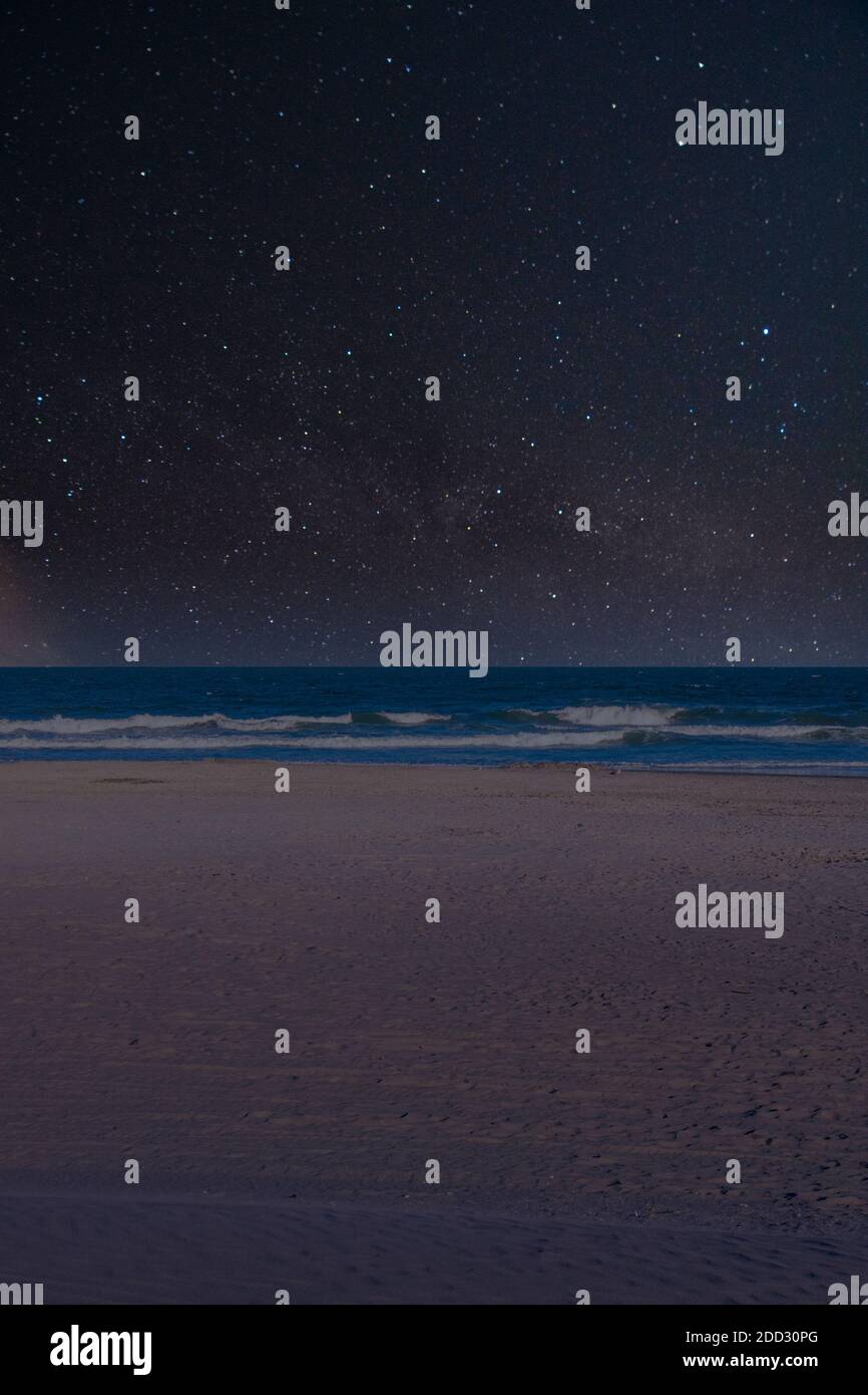 A Wide Open Beach Scene With a Man Walking Through the Scene With a ...