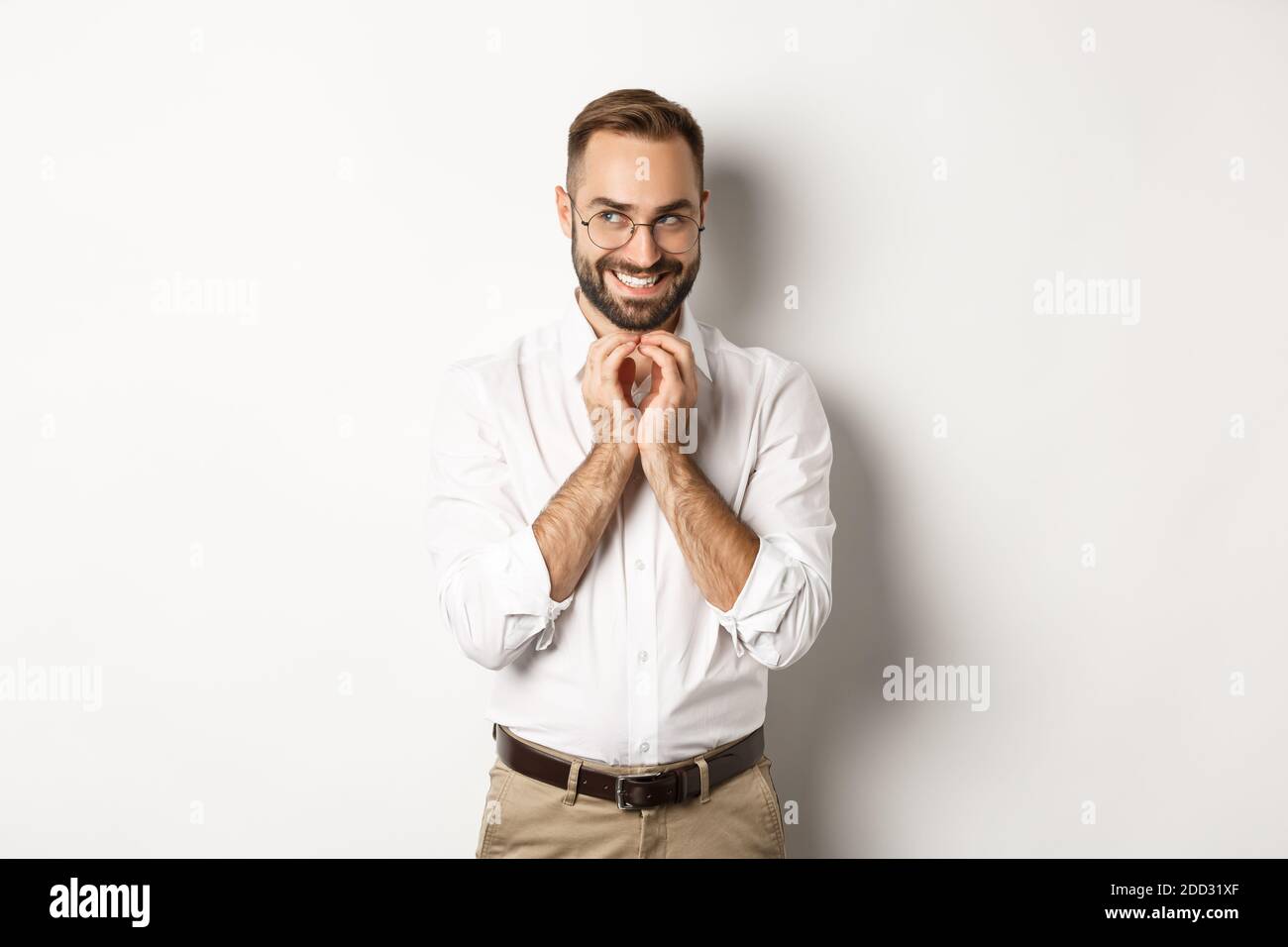 Young cunning businessman steeple fingers and smiling devious, scheming ...