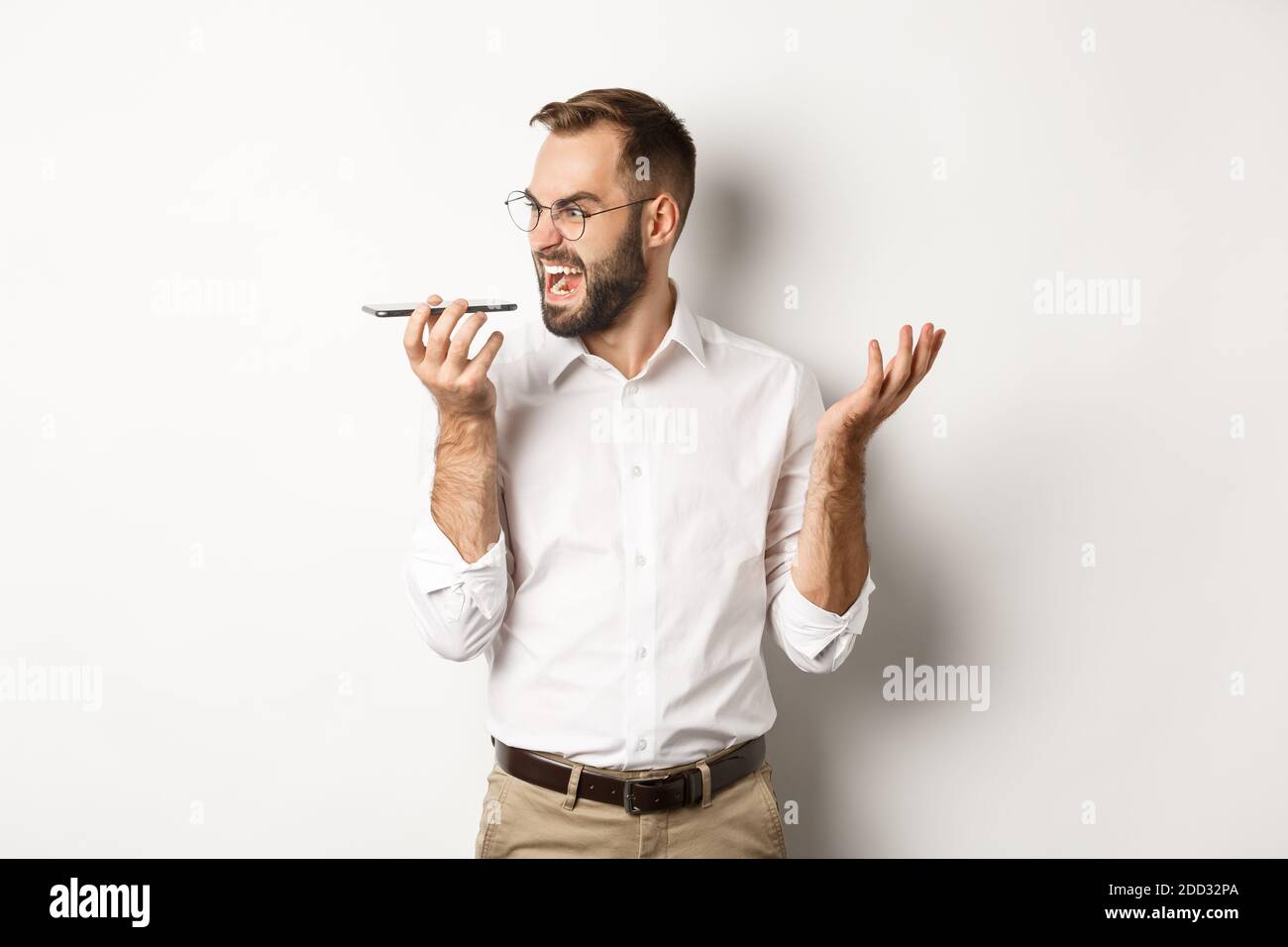 Angry business man shouting at speakerphone, record voice message in ...