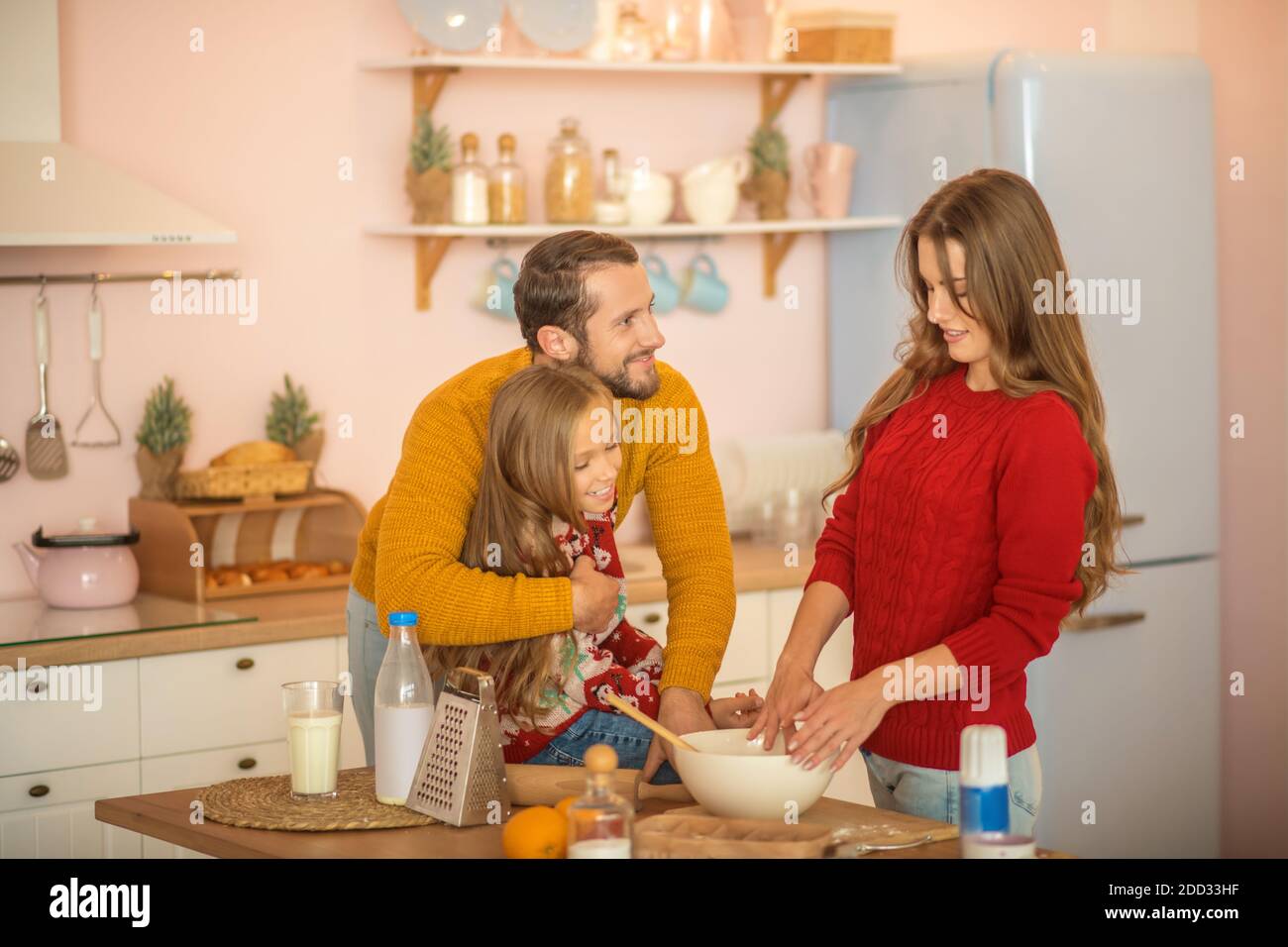 Kid and her parents cooking together in the kitchen Stock Photo - Alamy