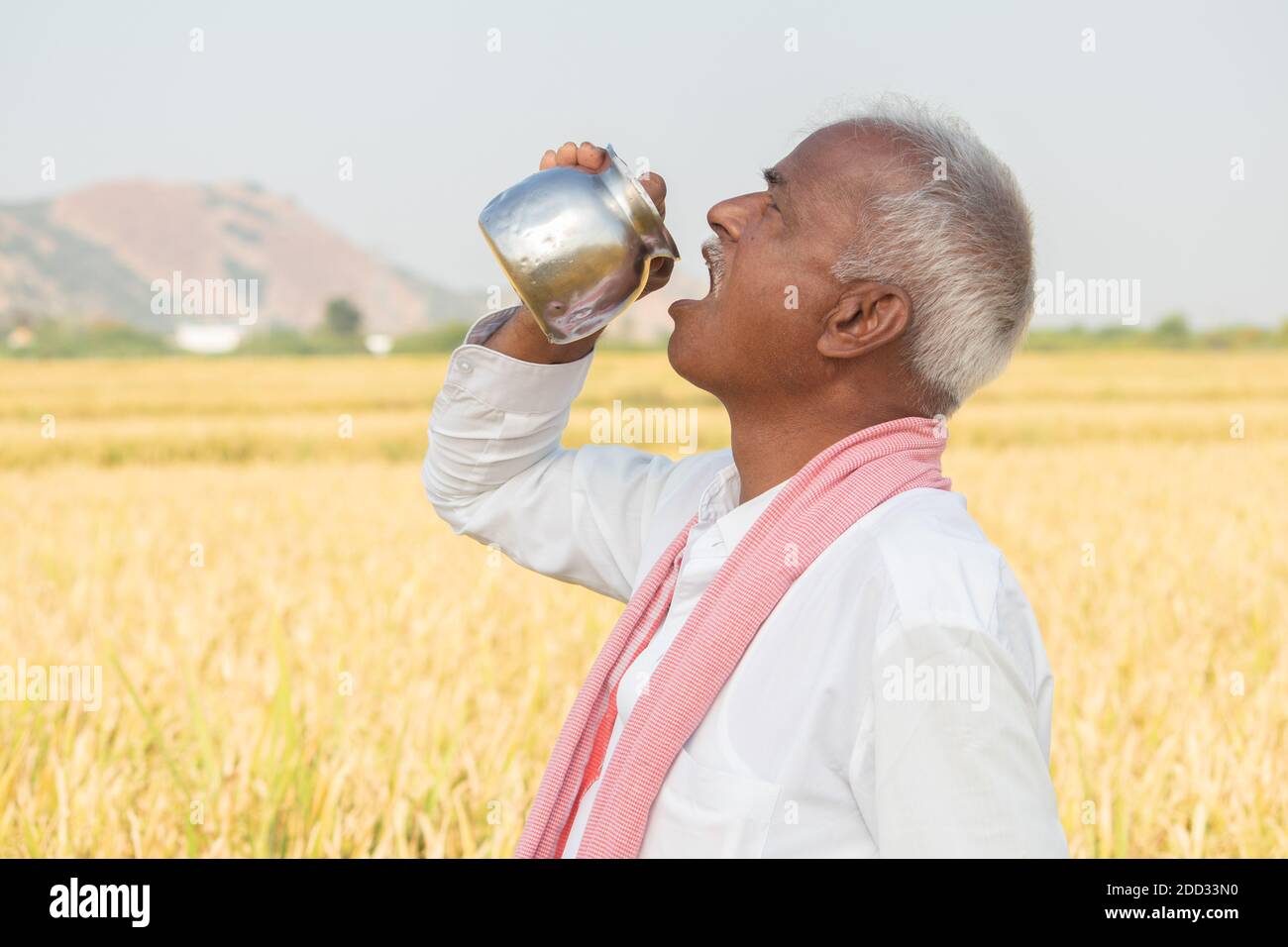 Thirsty Indian farmer drinking water from steel tumbler or Chambu on ...