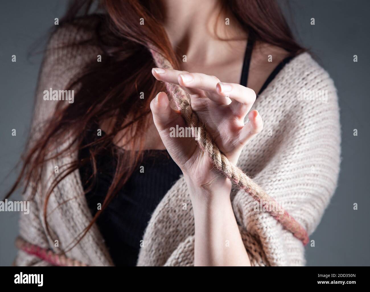 Image of young binded woman with rope on hand on grey background Stock ...