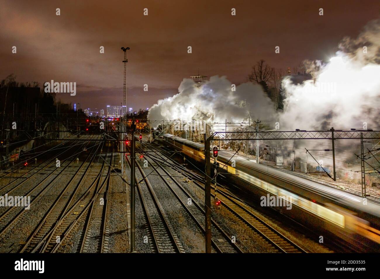 Night photo of an old steam locomotive walking along the railroad ...