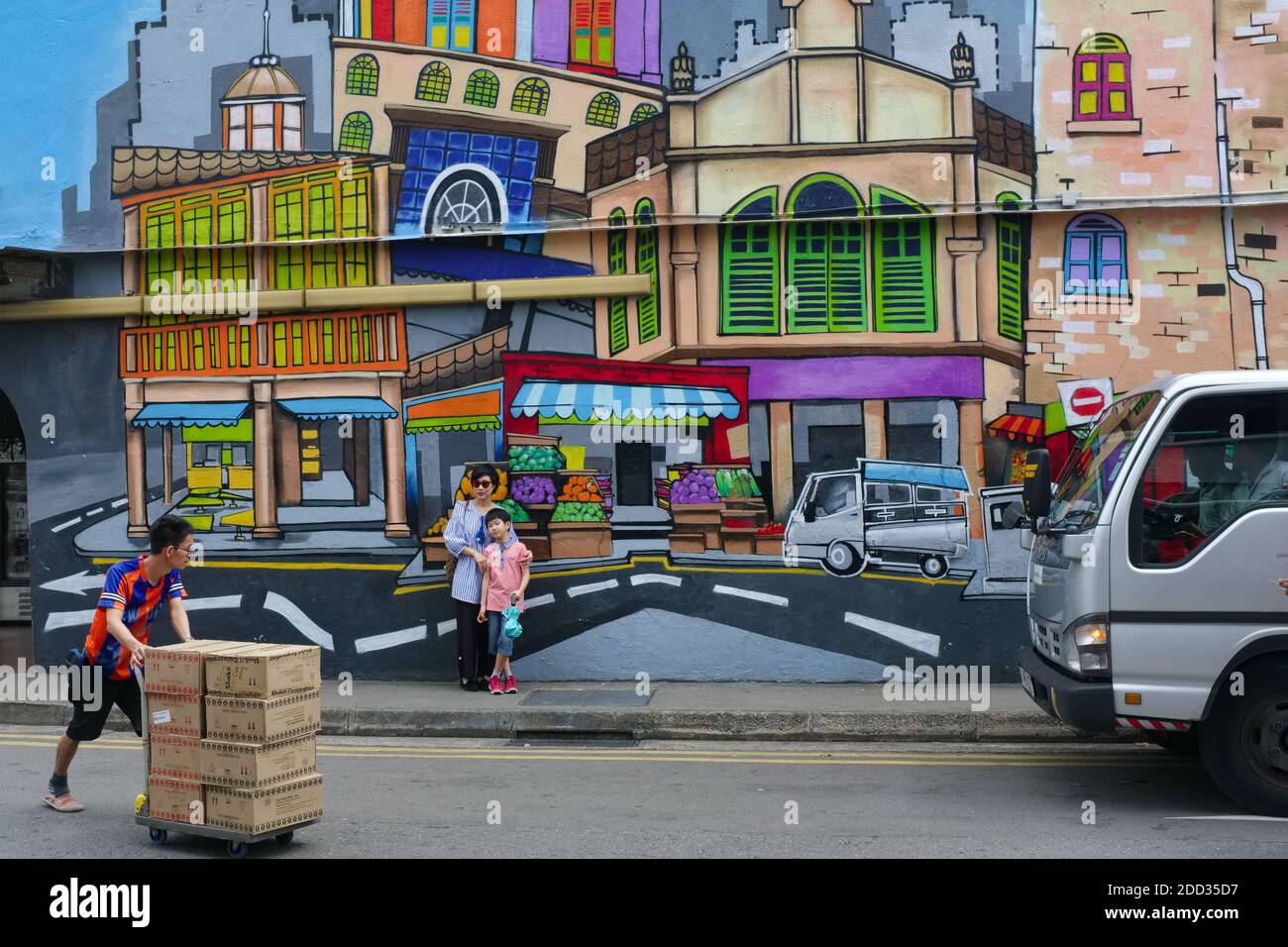 A mother and son posing in front of a large mural in Desker Road ...
