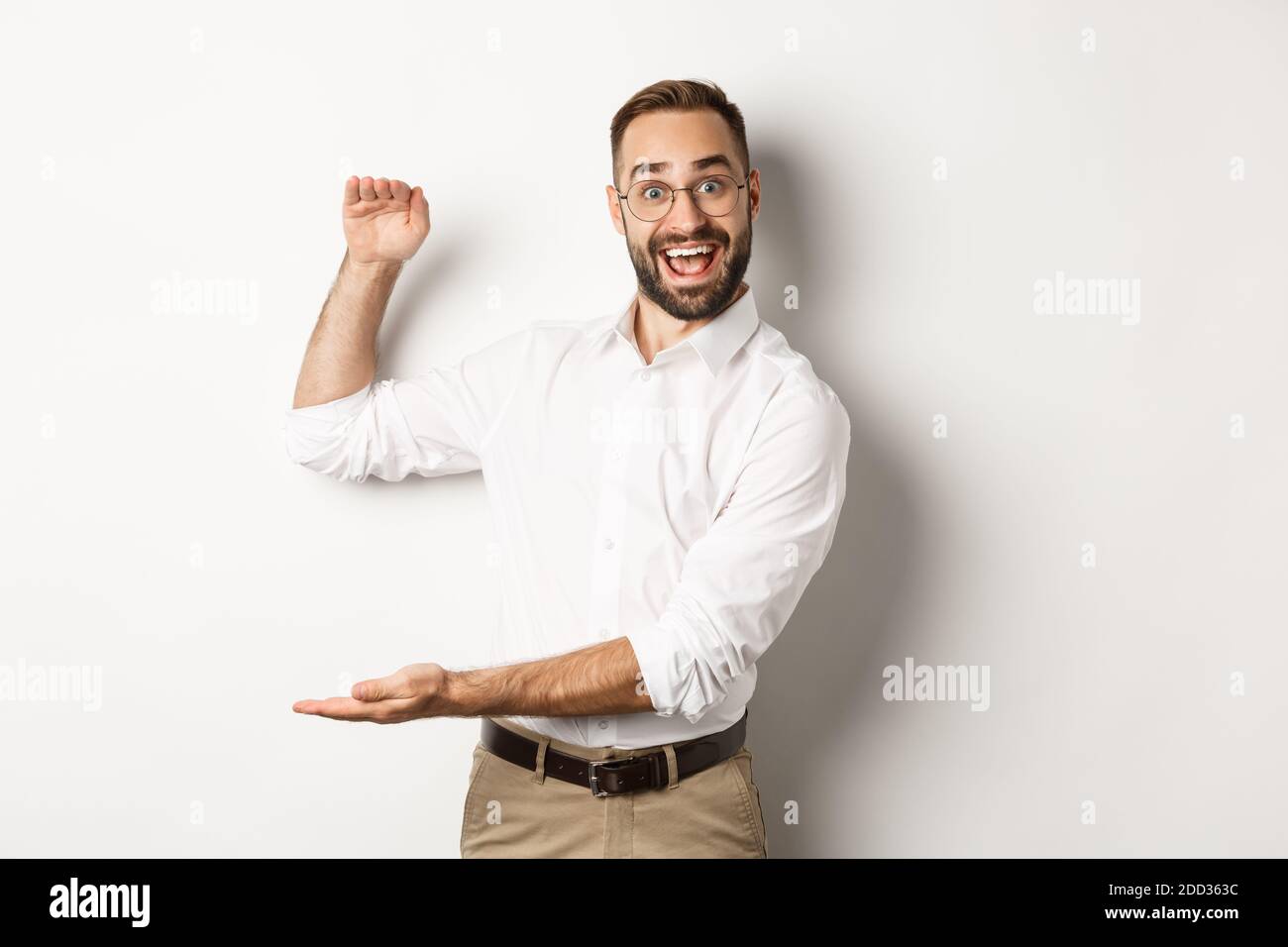 Amazed businessman showing big object, describe something large and ...