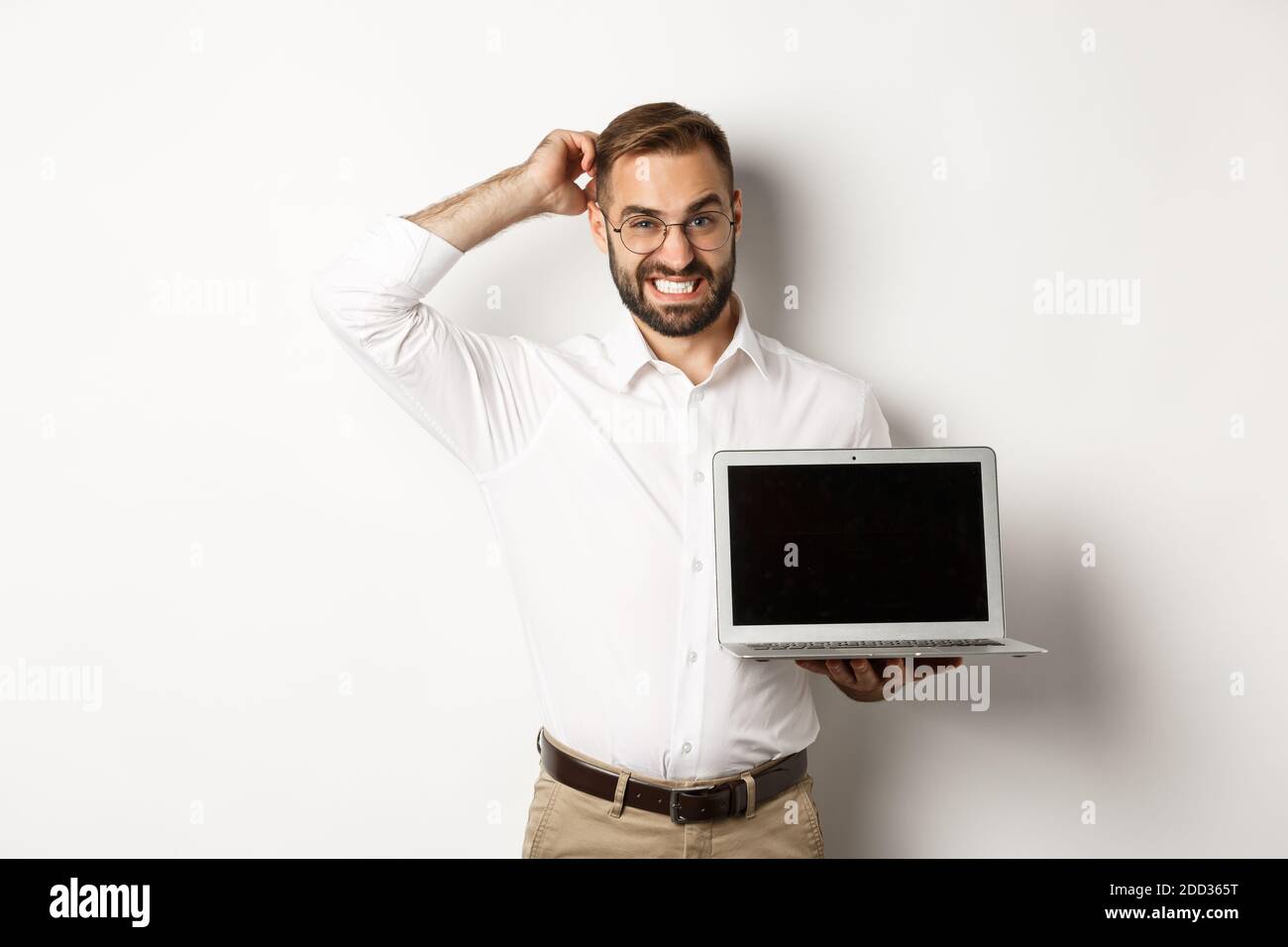Awkward business man showing laptop screen and looking doubtful ...