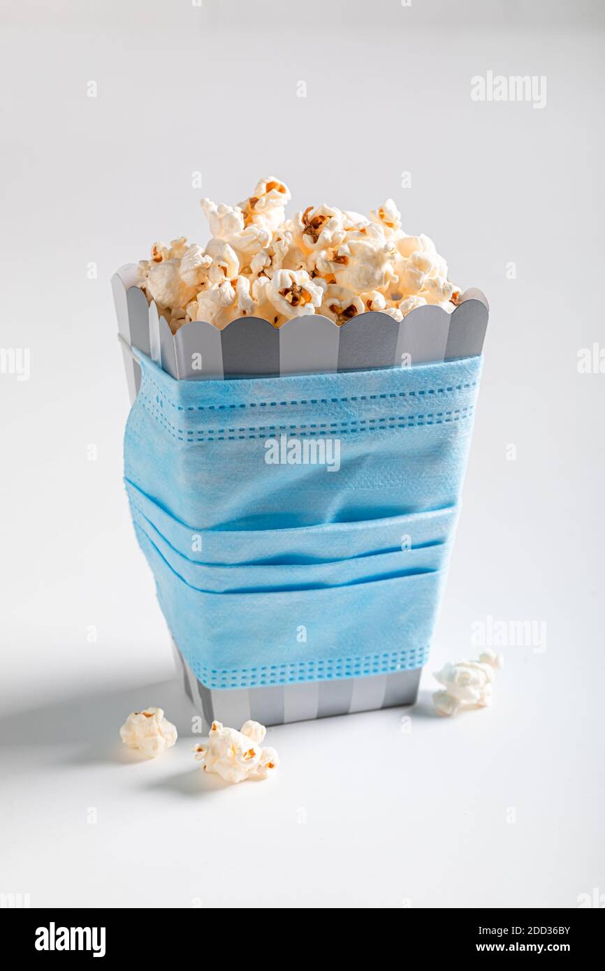 Disposable mask and popcorn on white background. COVID-19 coronavirus ...