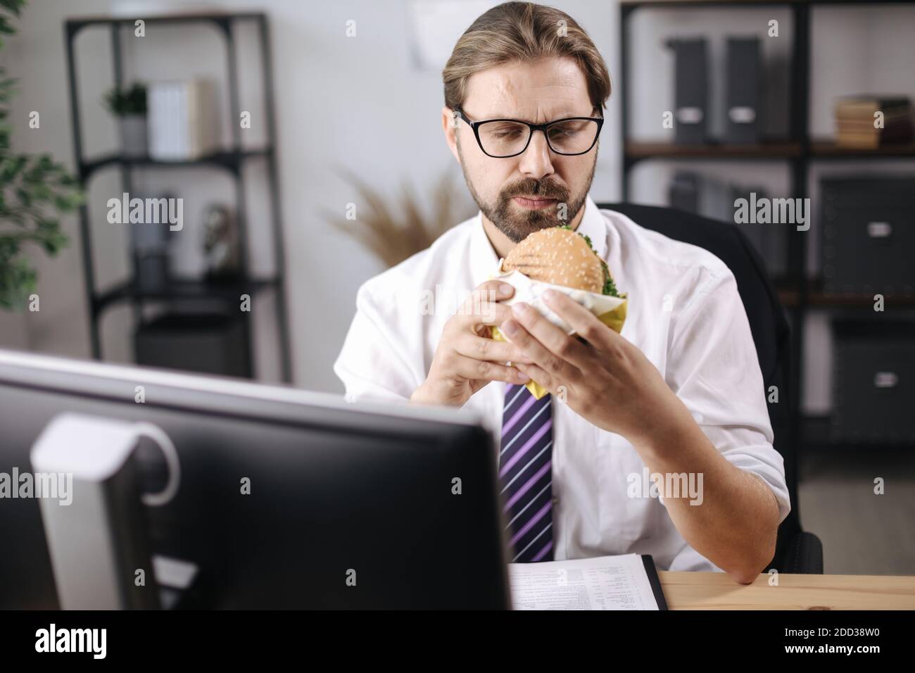 Busy man eating and working at office Stock Photo - Alamy