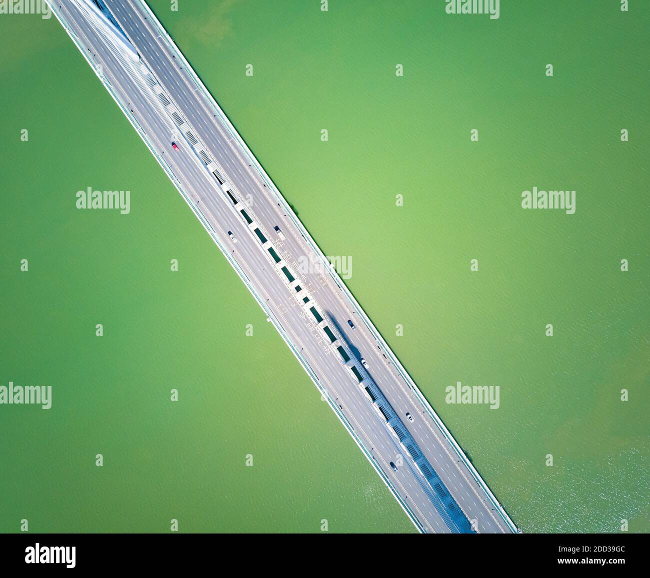 Pavement and vehicles of the bridge across the river, vertical aerial ...